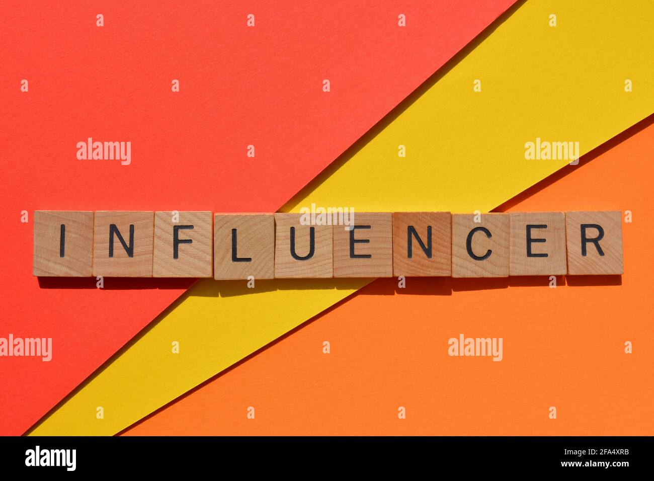 Influencer, word in wood alphabet letters isolated on bright red ...