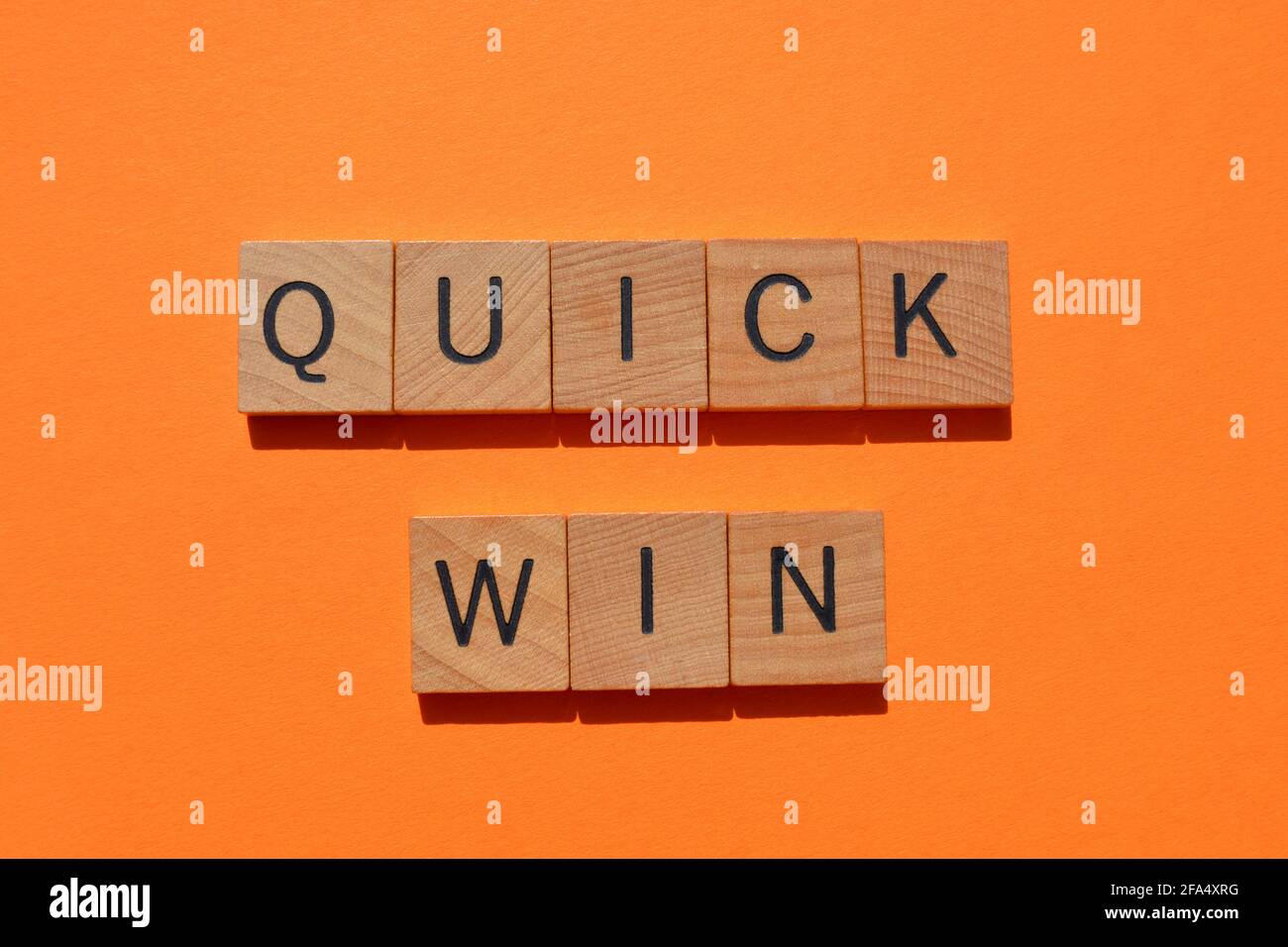 Quick Win, words in wooden alphabet letters isolated on orange ...