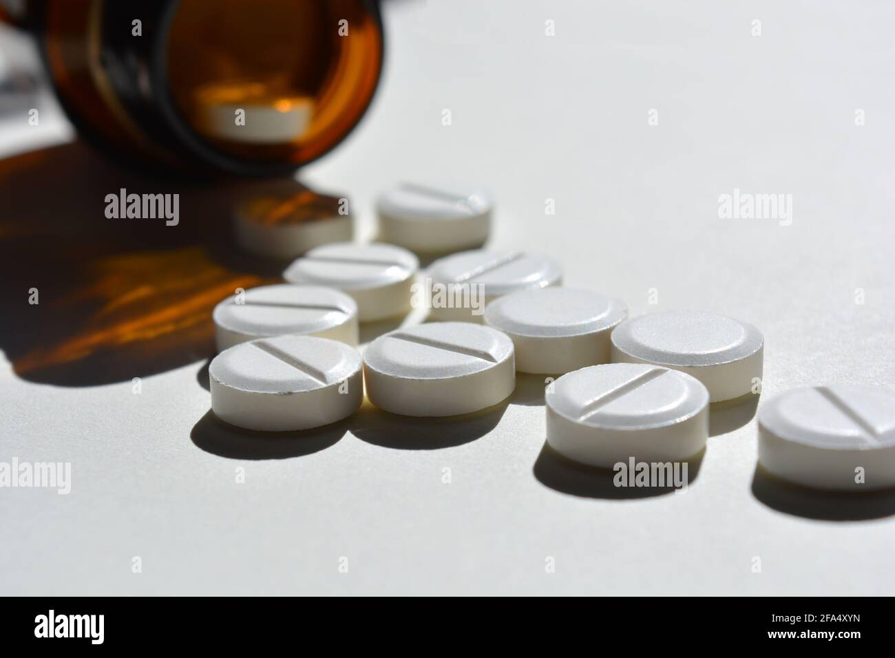Generic white tablets spilling out of brown glass bottle, isolated on ...