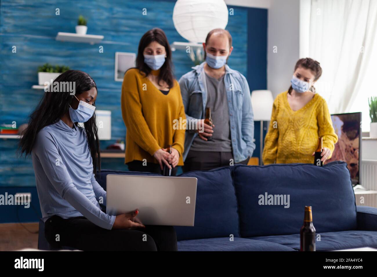 Multiracial group of friends chatting using laptop keeping social ...