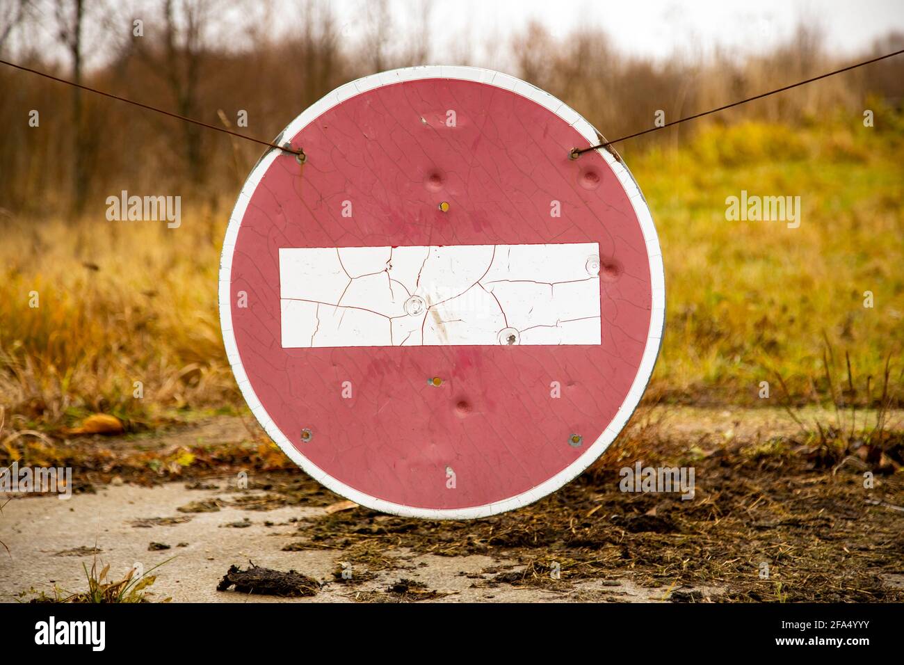 old rusty no entry sign on an old abandoned road in a field. close up ...