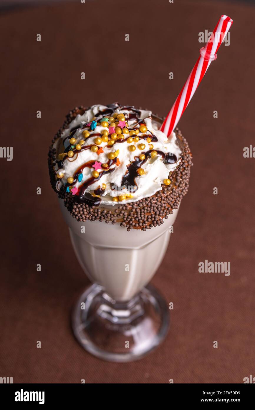 sweet milkshake with a tube on a brown background Stock Photo - Alamy