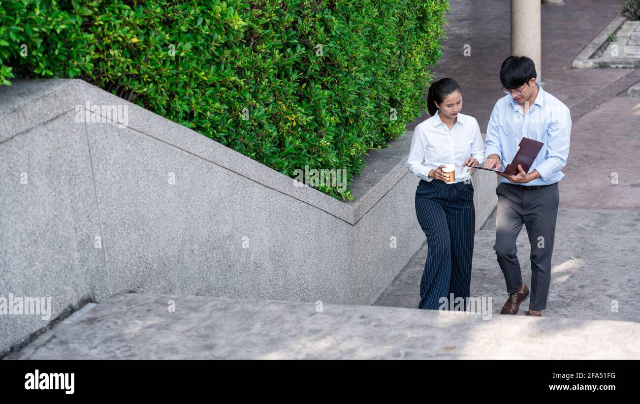 Business colleagues discussing work issues outdoor near the office ...