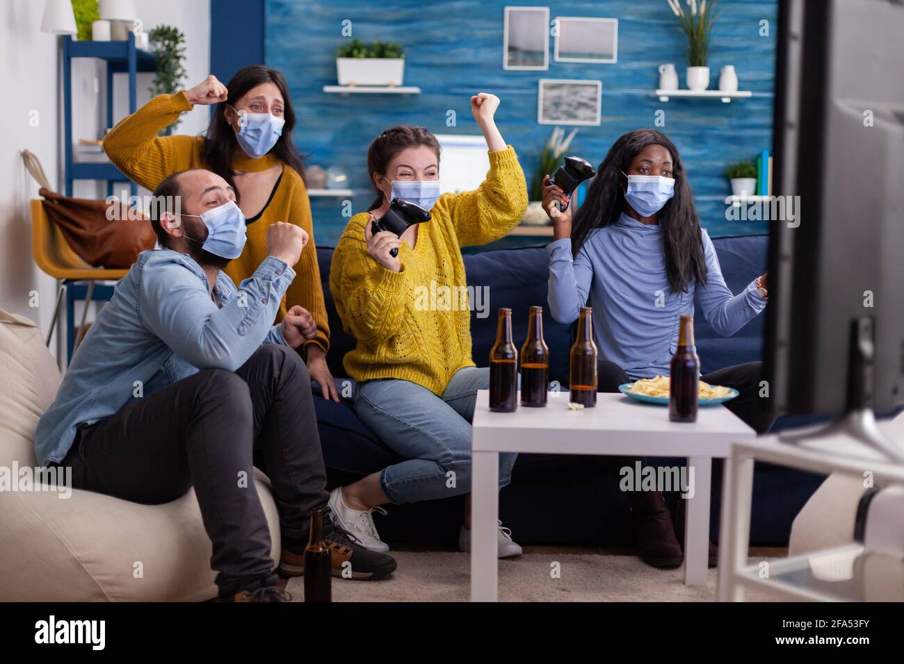 Excited multiracial gamer women sitting on couch playing video games on ...