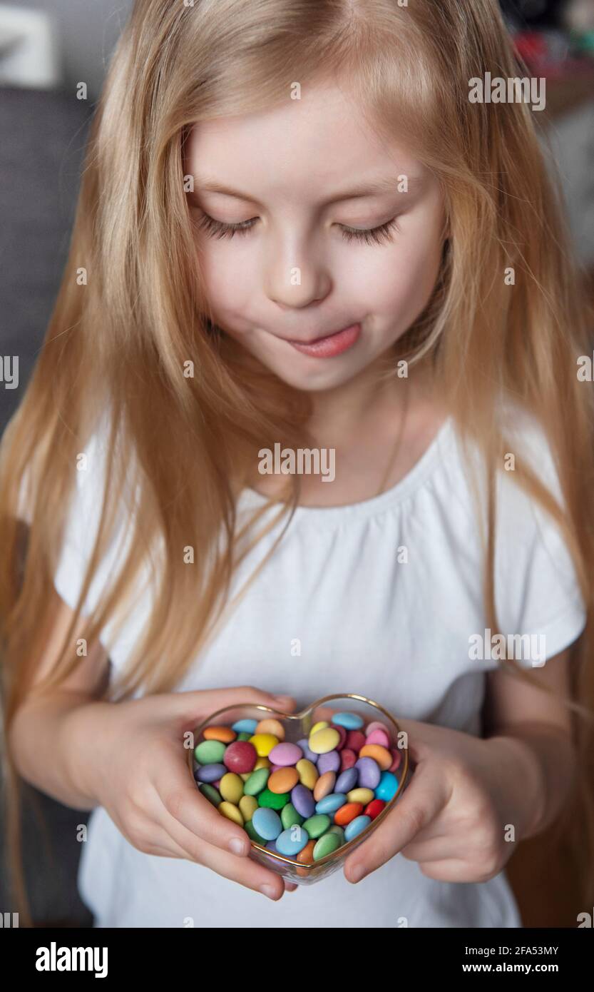Little girl holding a bowl of colorful sweet candies Stock Photo - Alamy