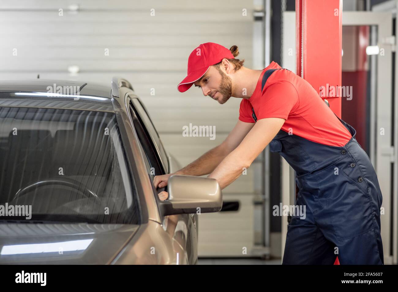 Auto mechanic standing near open window of car Stock Photo - Alamy