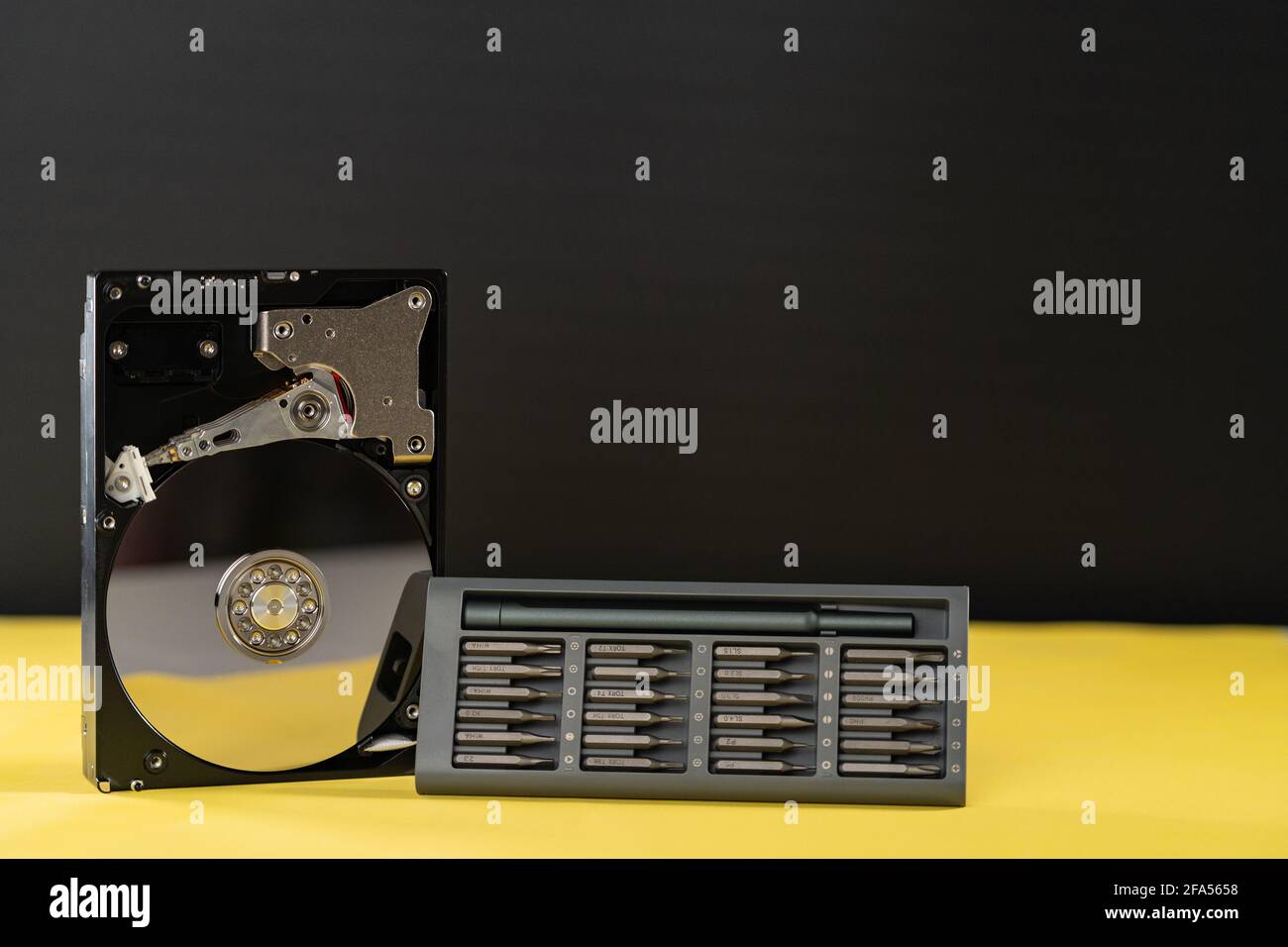 hdd disk with screwdriver repair kit on yellow black background Stock ...