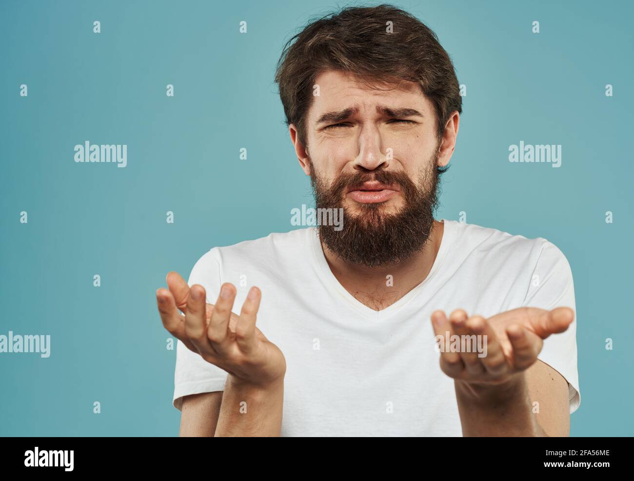 Emotional guy gesturing with his hands on a blue background Copy Space ...