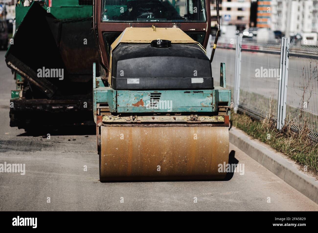 Road construction works with an industrial machine and an asphalt paver ...