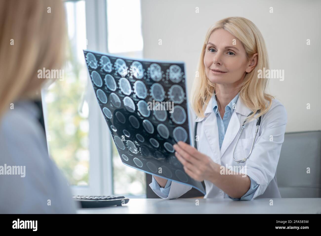 Doctor with MRT scan and patient communicating Stock Photo - Alamy