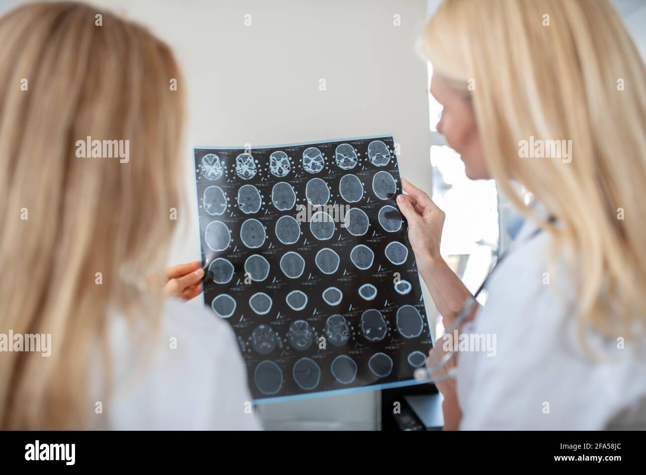 Two doctors standing with their backs examining MRT scan Stock Photo ...