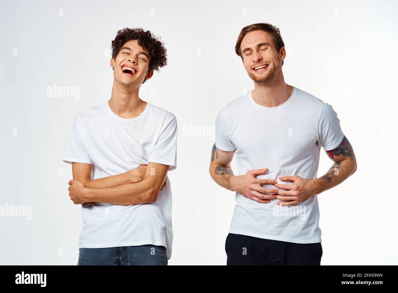 two funny friends in white t-shirts laughing positive emotions Stock ...