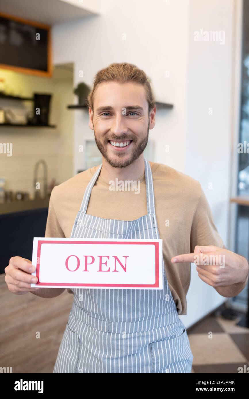 Happy man showing that cafe is open Stock Photo - Alamy