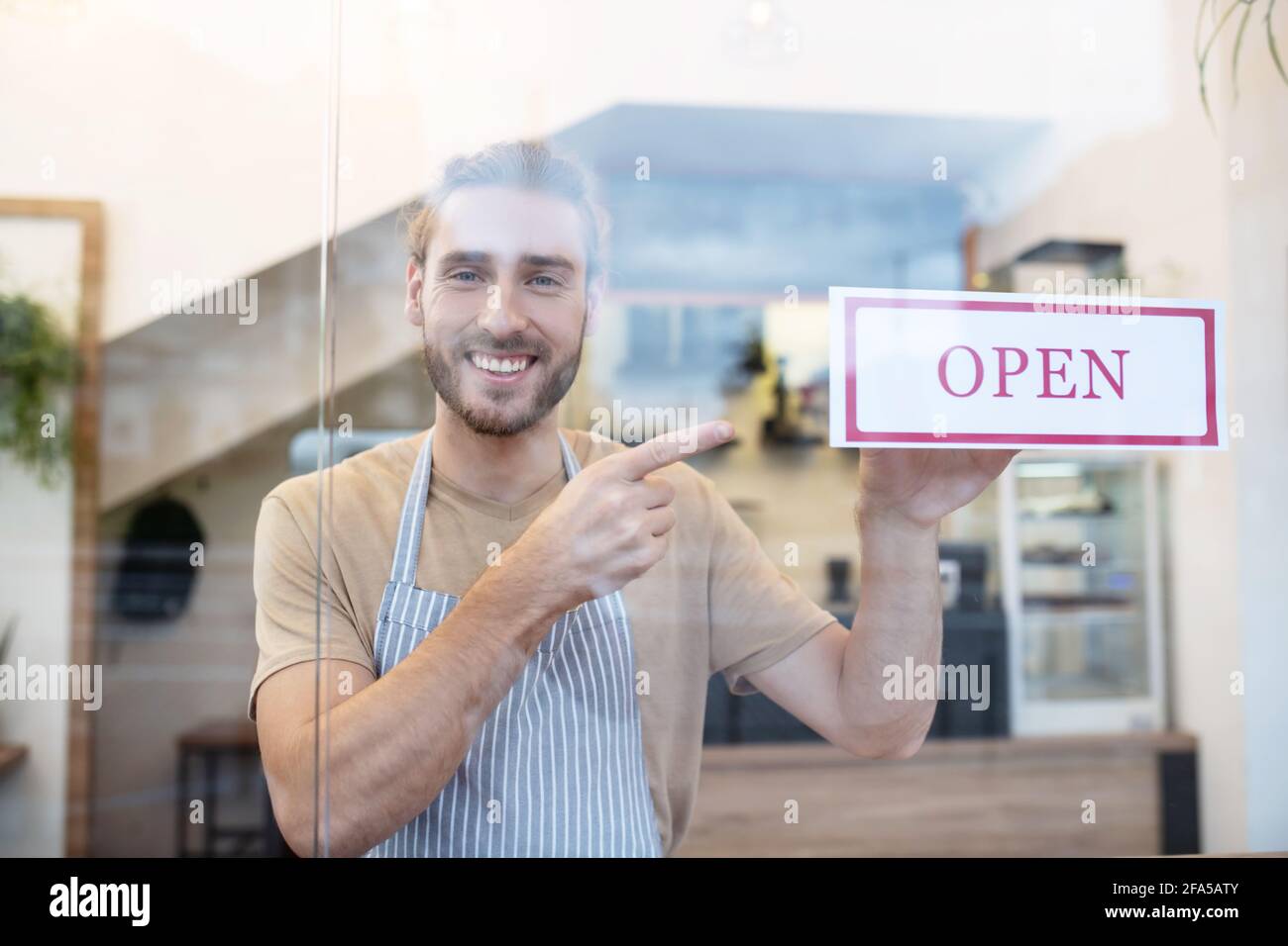 Man pointing at sign at entrance to cafe Stock Photo - Alamy