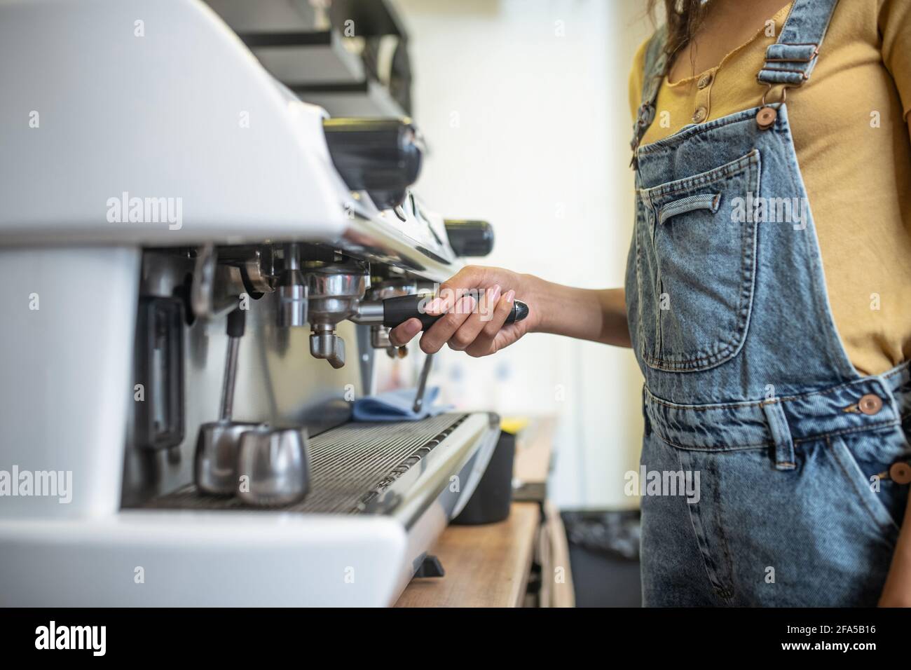 Female hand holding lever of coffee machine Stock Photo - Alamy