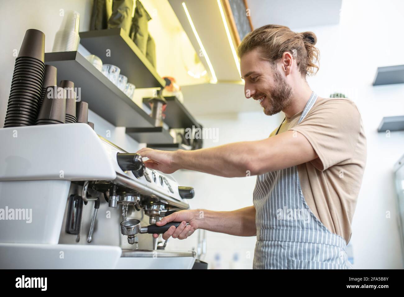 Knowledgeable man cleaning filter of coffee machine Stock Photo - Alamy