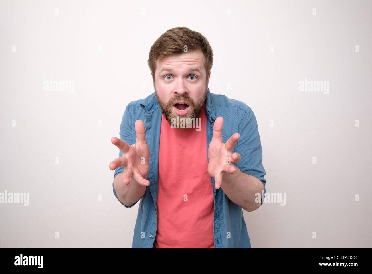 Disgruntled, annoyed bearded man looks inquiringly with mouth open and ...