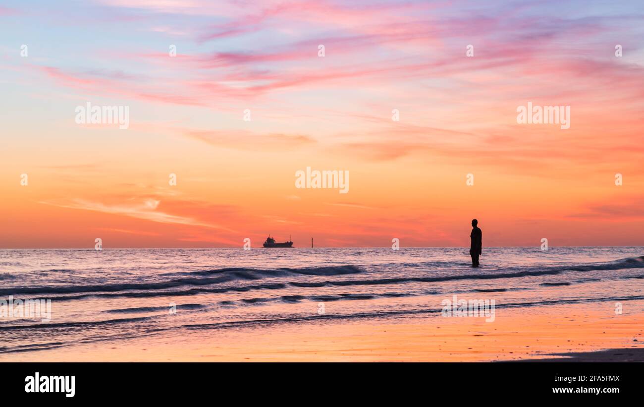 A lone Iron Man watches a large boat going out into the Irish Sea at ...