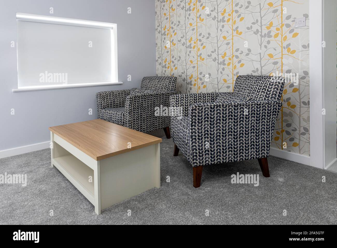 Two arm chairs and a table in a stylish room Stock Photo - Alamy
