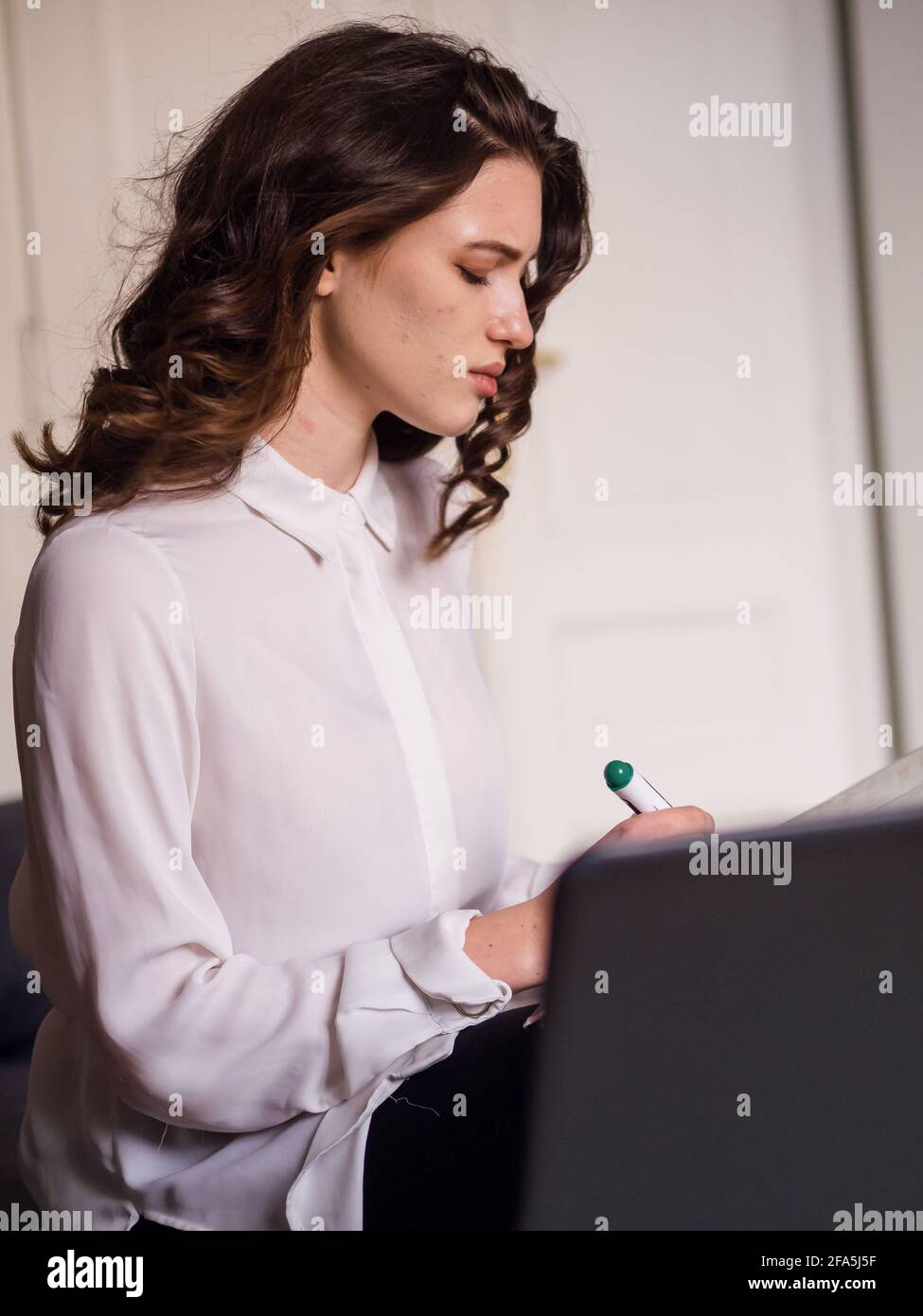 one young worried young woman, writing on whiteboard at her home Stock ...