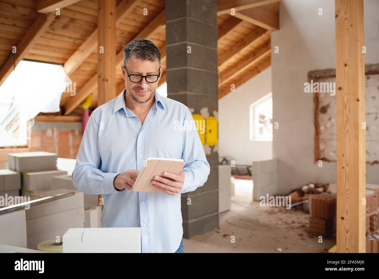 male architect middle age with black glasses stands on construction ...