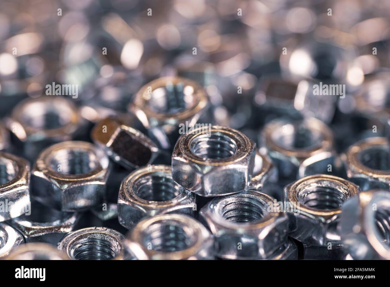 Close-up metal chrome nuts in a chaotic order. Background concept for ...