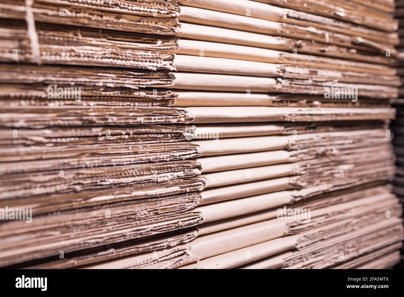 Close-up large cardboard piles lie on top of each other in a warehouse ...