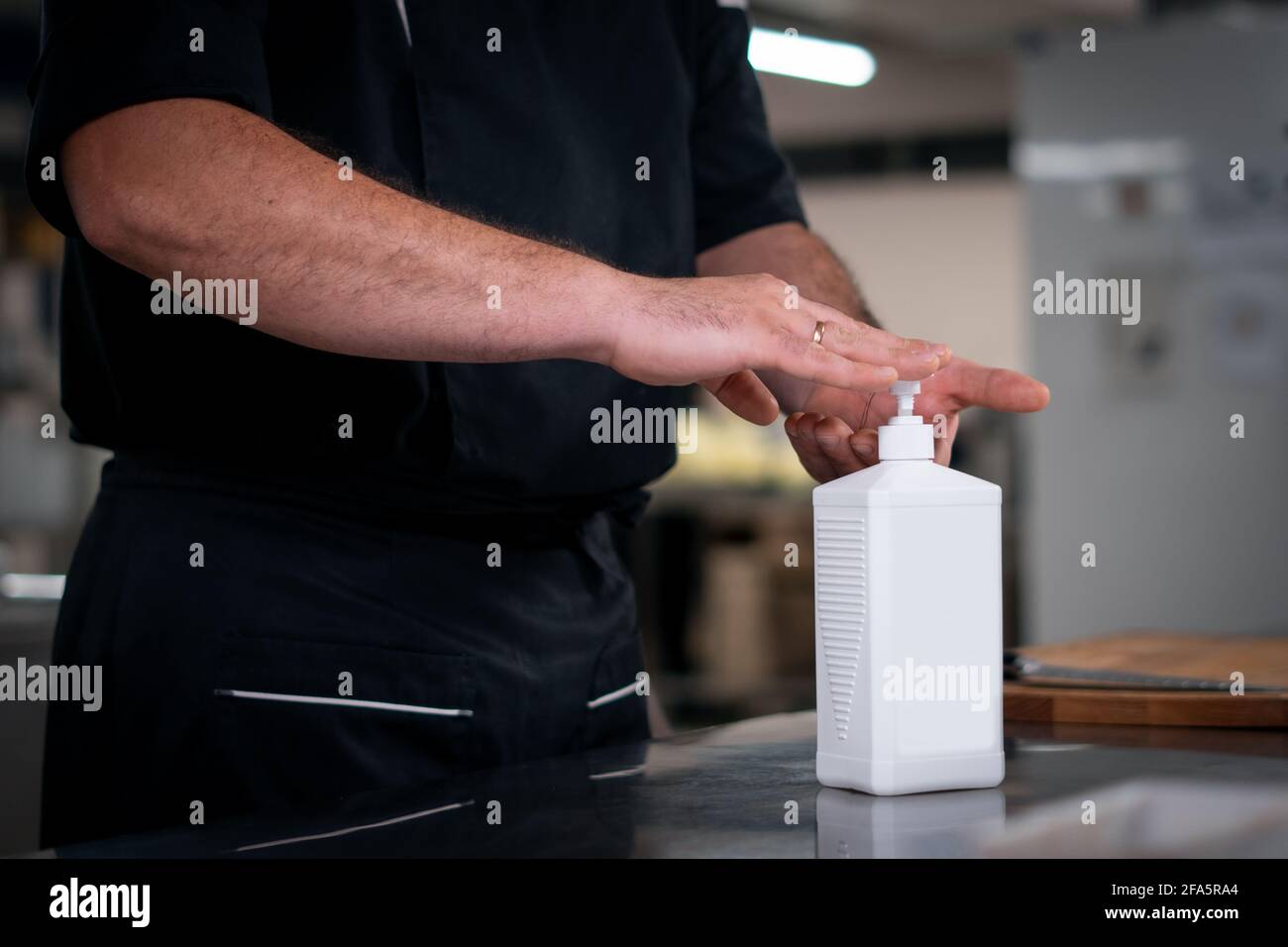 close up of chef cook applying disinfection liquid antiseptic gel ...