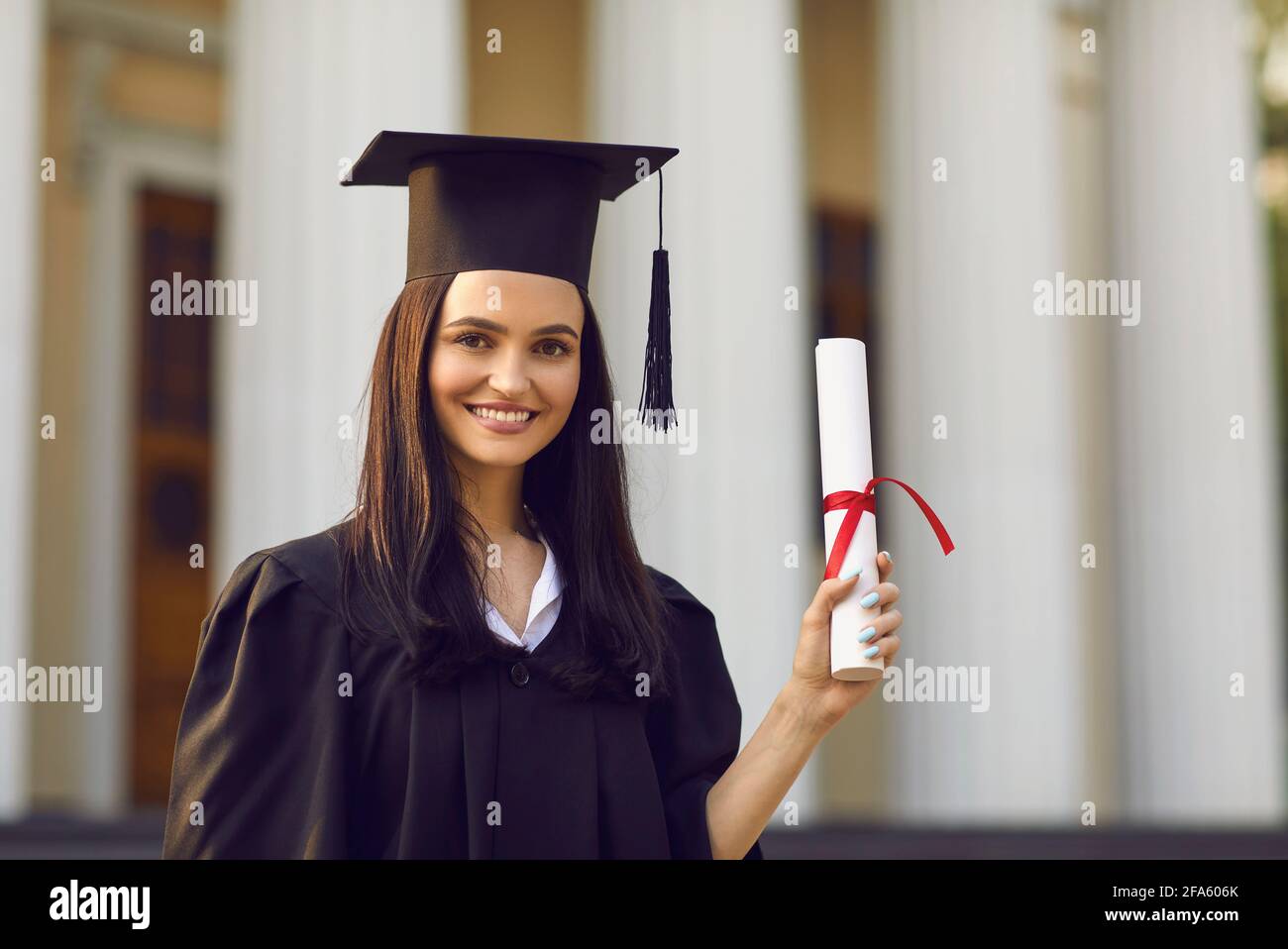 Smiling girl university graduate standing with diploma in hand Stock ...
