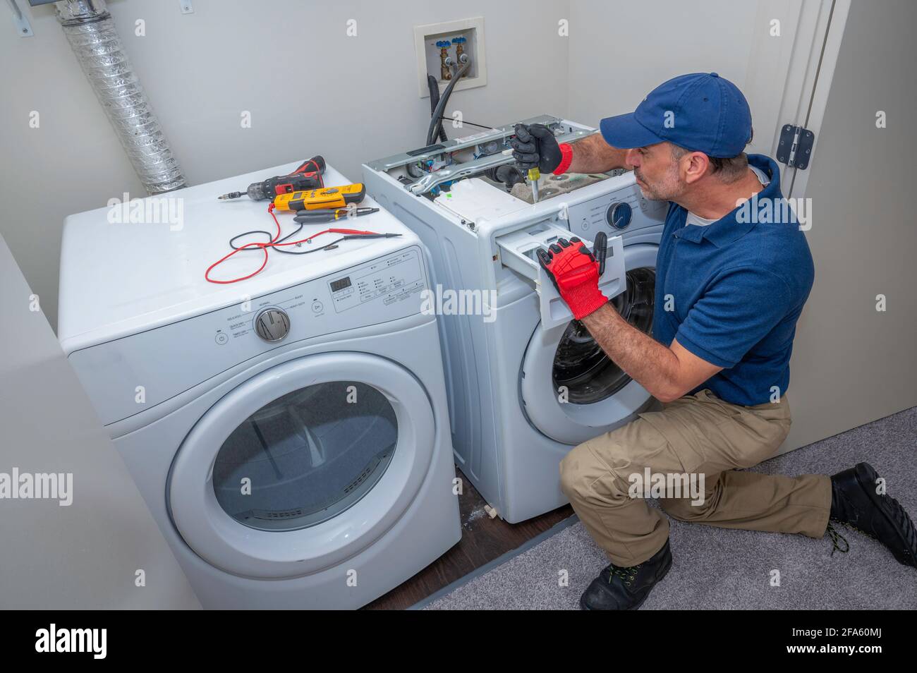 Appliance technician working on a front load washing machine in a ...
