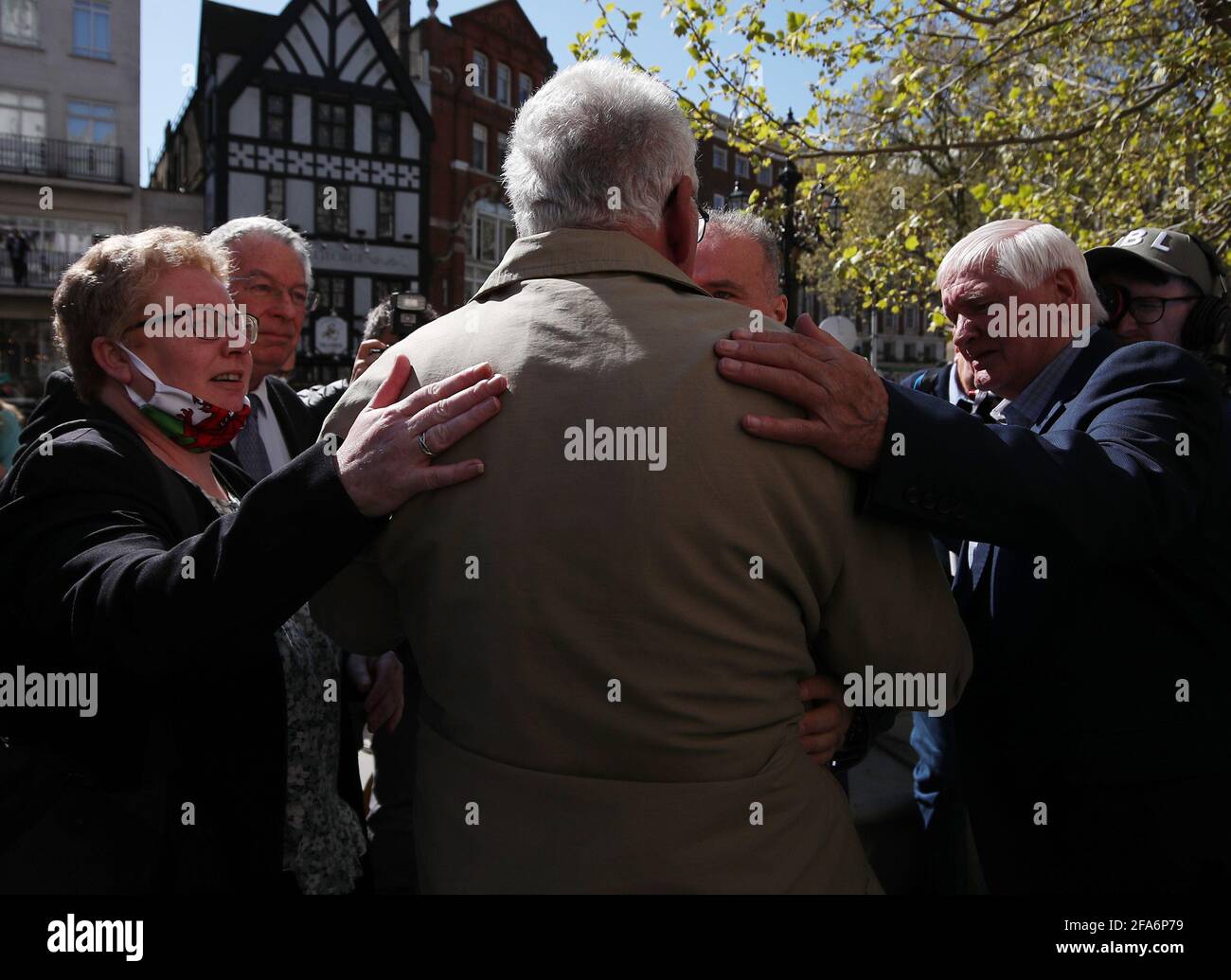 Former post office worker Noel Thomas (centre, back to camera), who was ...