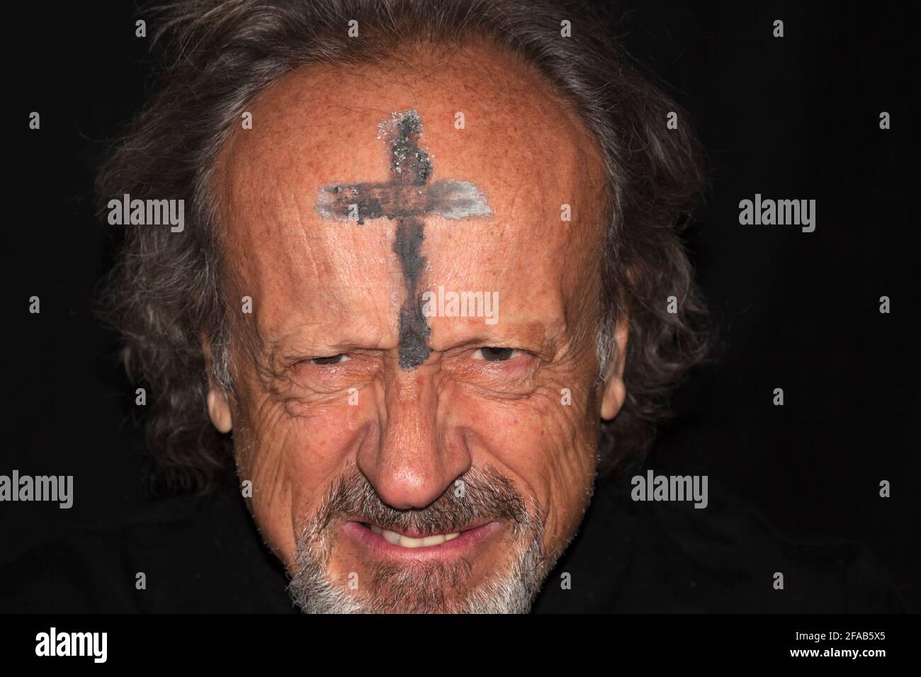 Fanatical prayer with ash cross on his forehead Stock Photo - Alamy