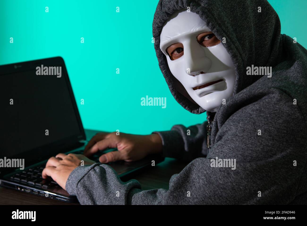 Thief hacker in mask stealing personal information from laptop. Concept ...