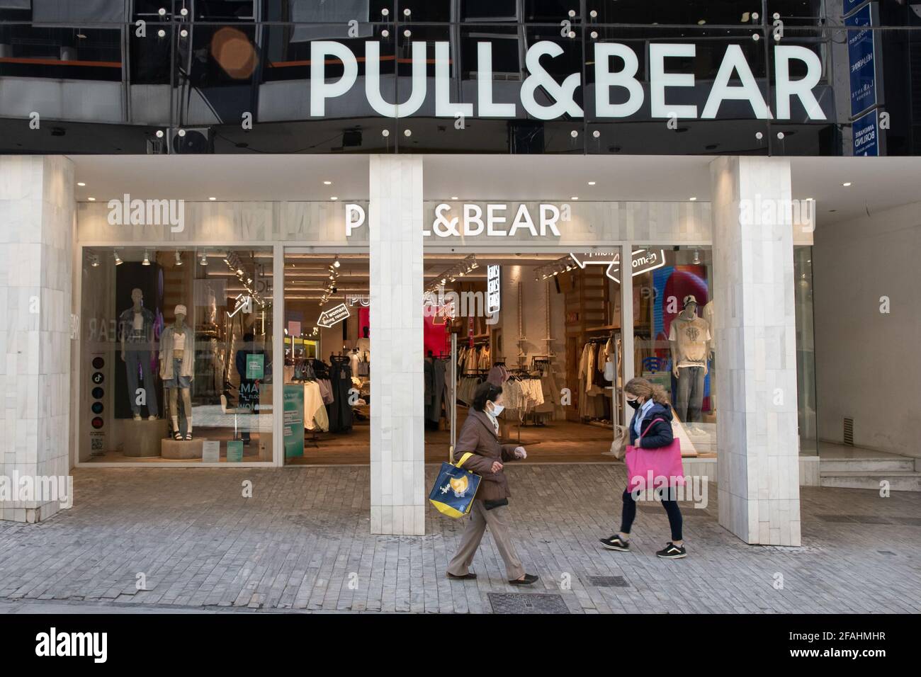 People seen walking past a Pull & Bear store at Ermou street close to ...