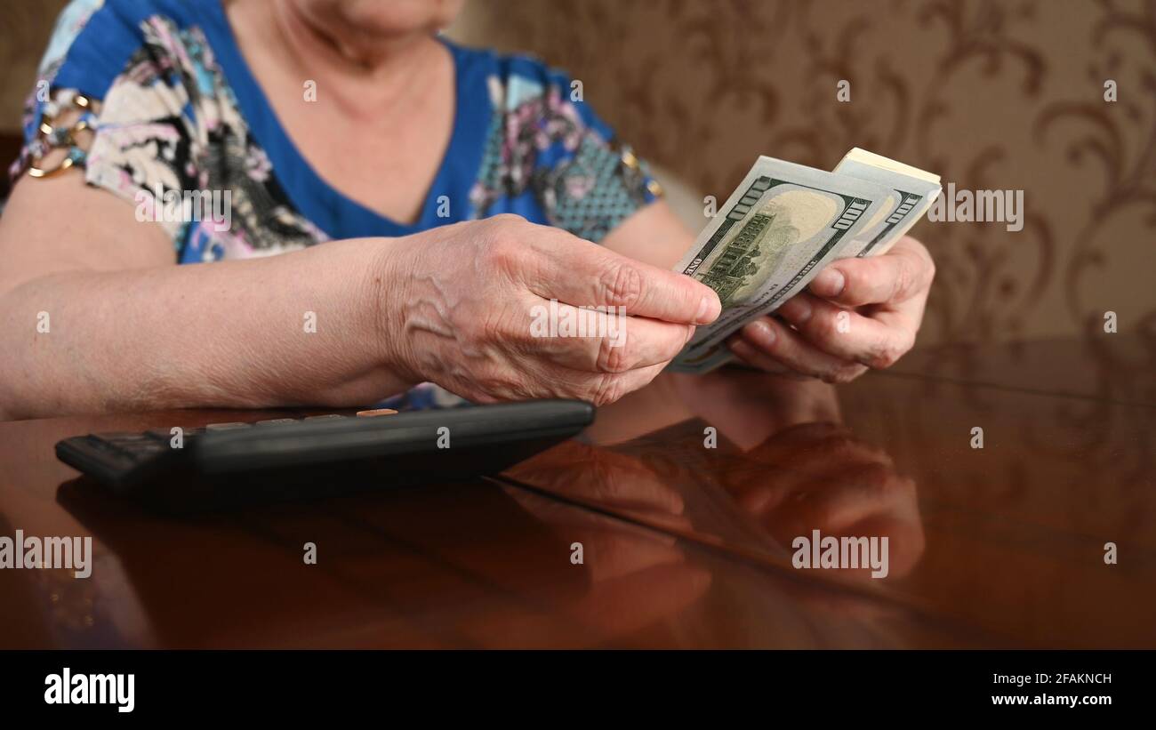 Old woman counting hundred dollar bills Stock Photo - Alamy