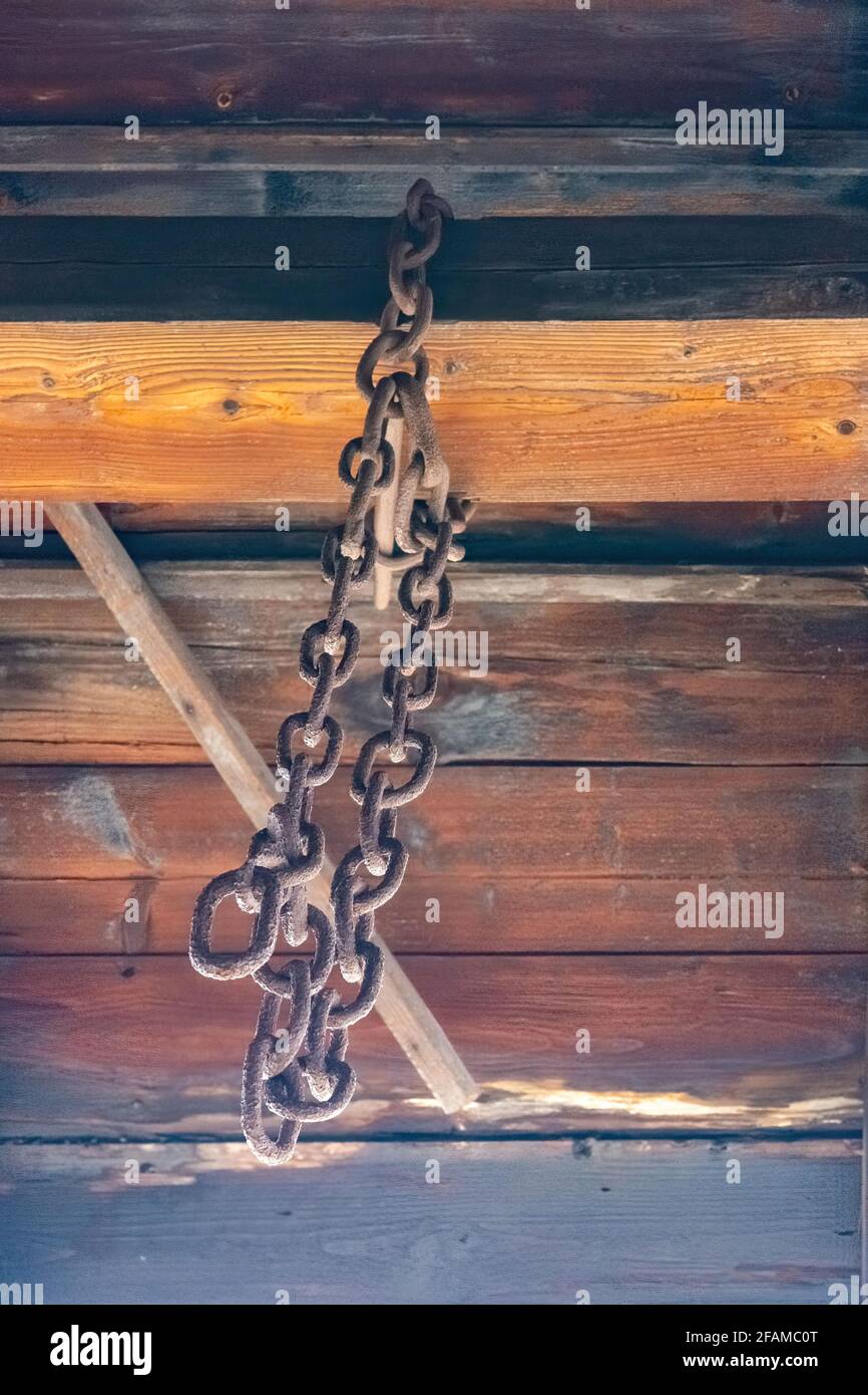 Low angle of a rustic chain hanging on a rural wooden ceiling Stock ...