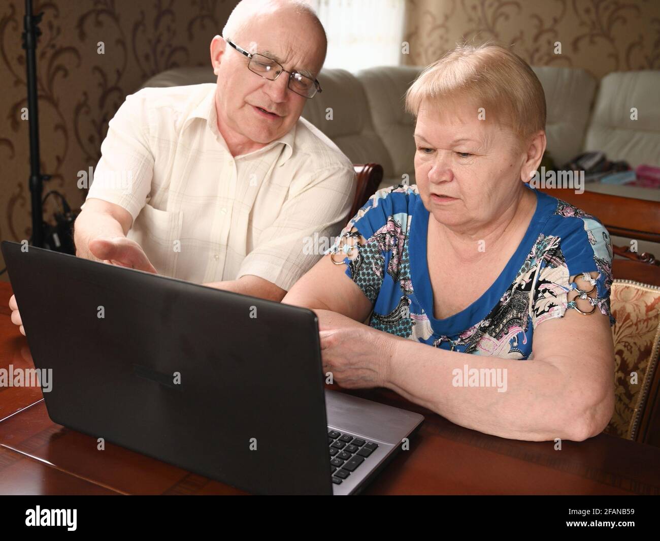 Elderly married couple sitting at the computer upset by what they saw ...