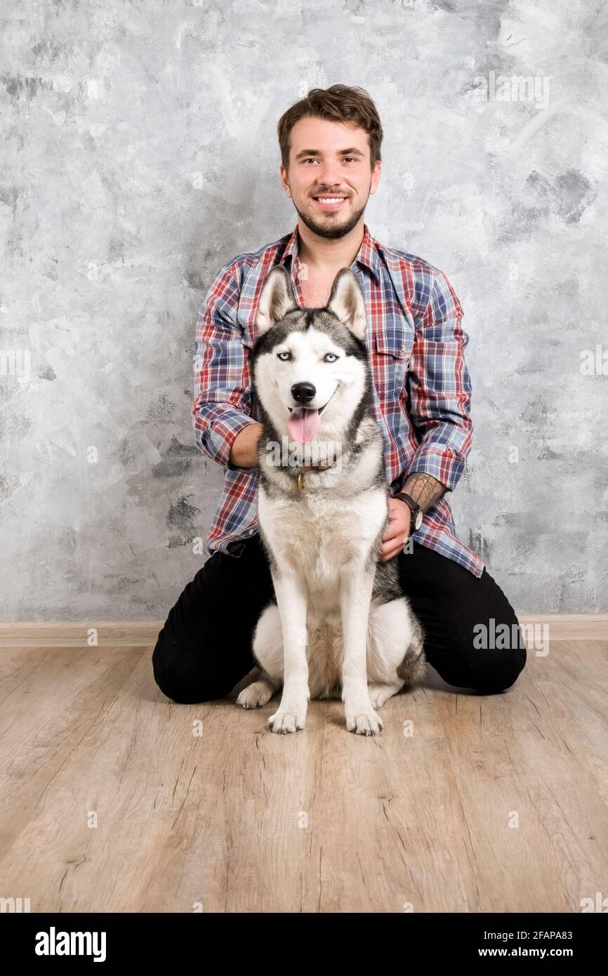 Young bearded man hanging out out with his husky dog. Hipster male ...