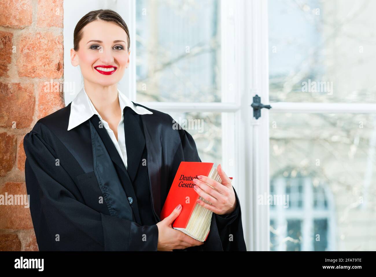 Young female lawyer working in her office reading in a typical law book ...