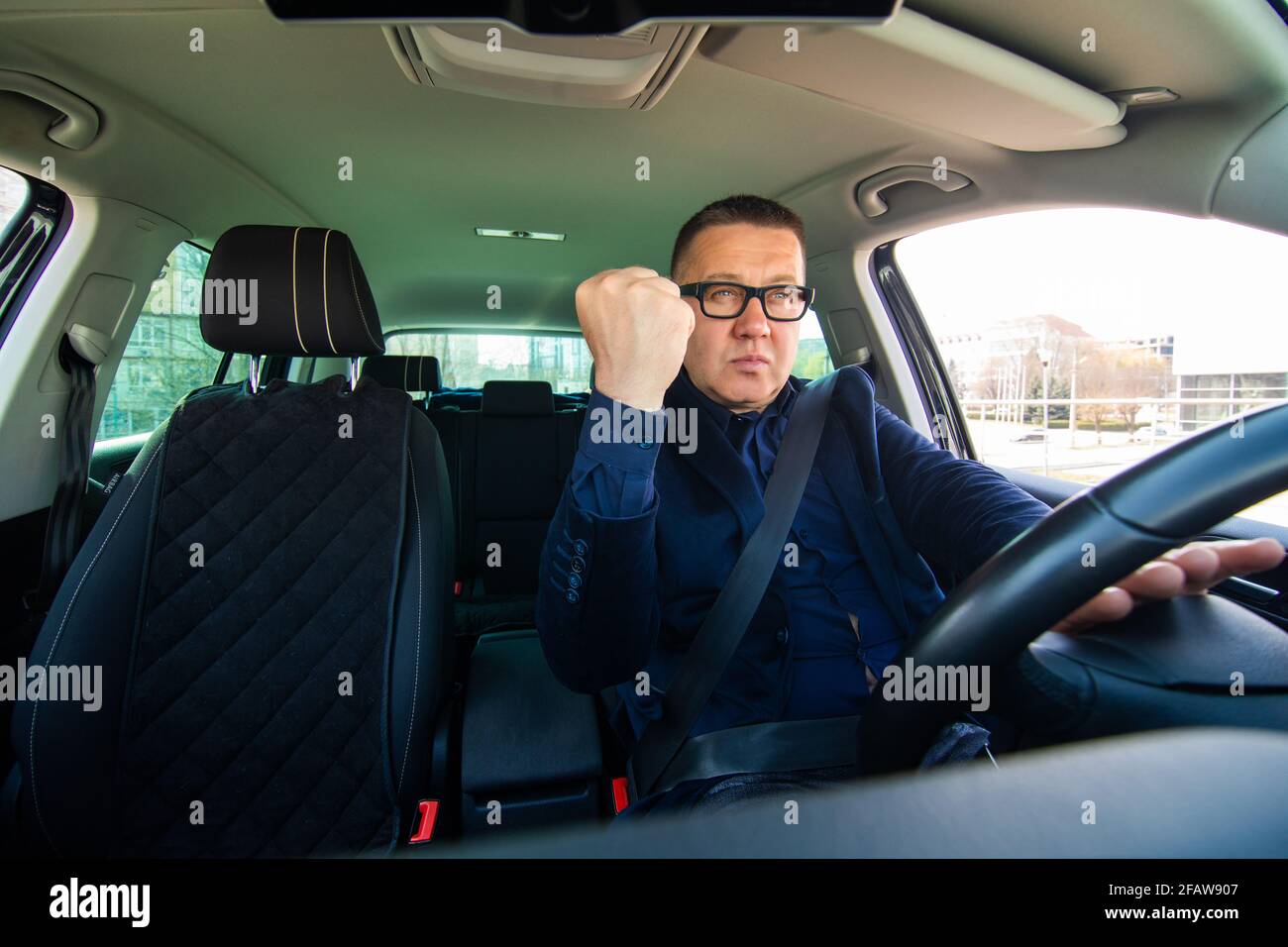 Angry middle age man looking outside from car window with fist up Stock ...