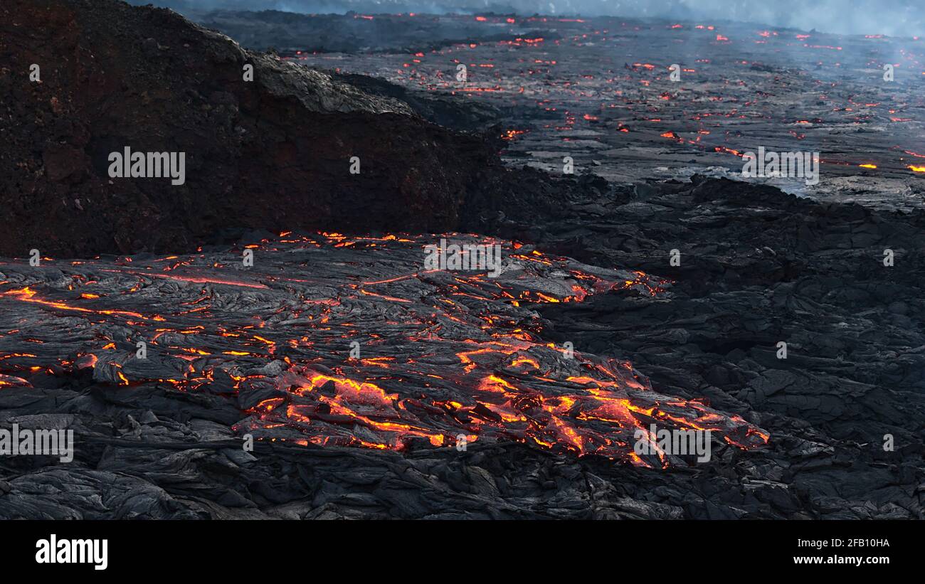 Stunning view of flowing lava with glow at eruption site of volcano in ...
