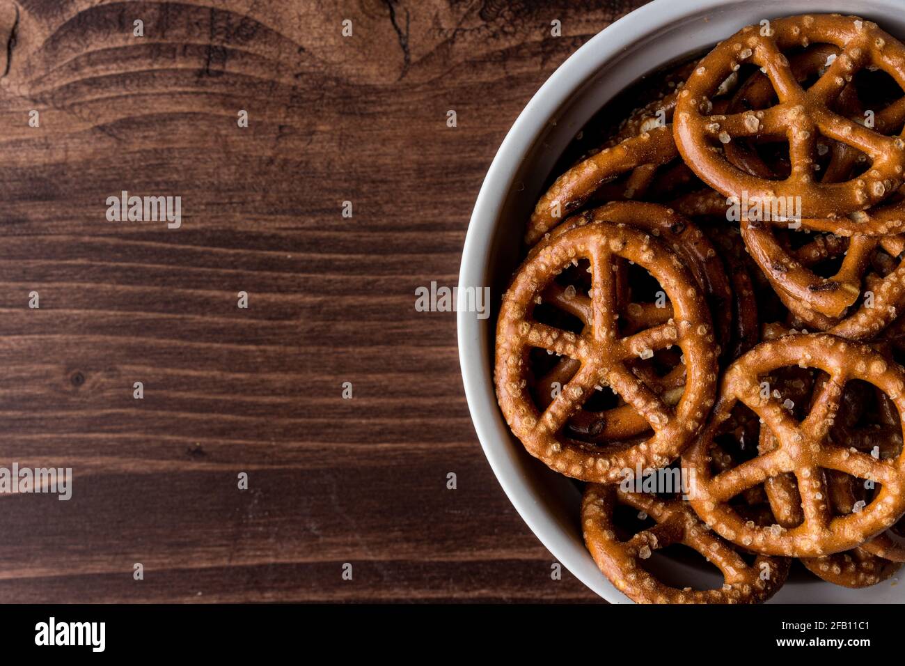 Top view of salty pretzels in the bowl on the wooden table with copy ...