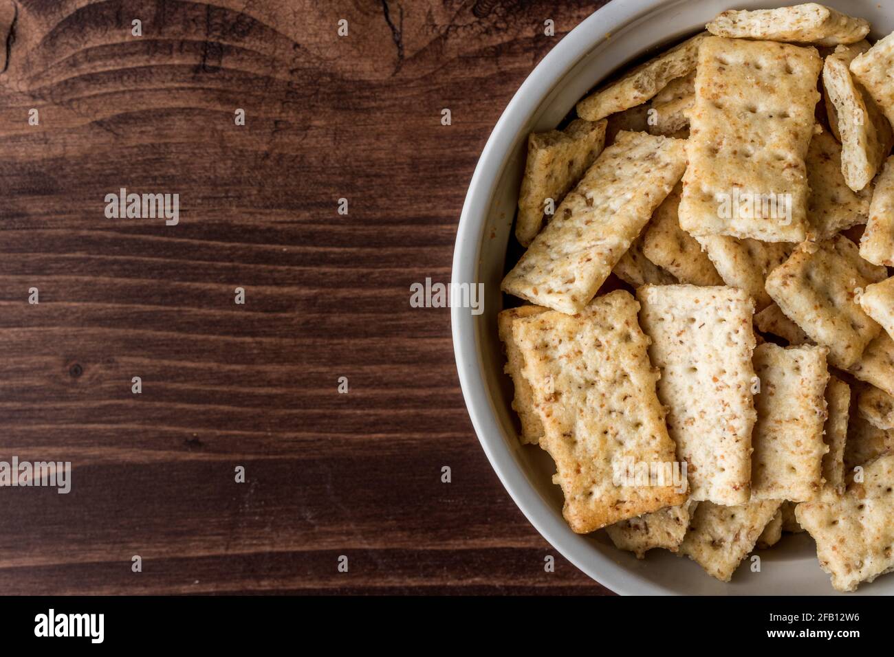 Top view of rectangular crackers in the bowl on the wooden table with ...