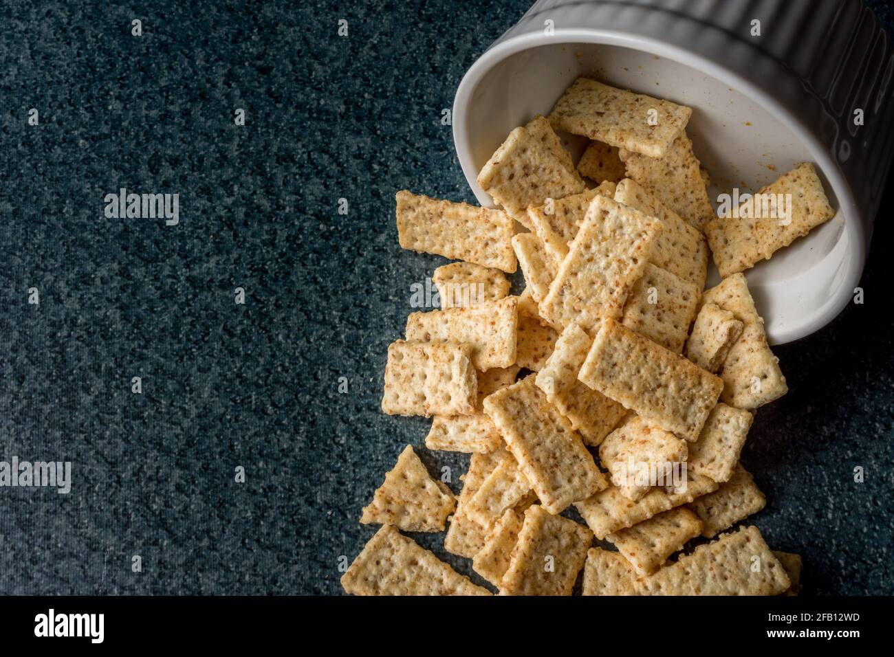Rectangular crackers poured out from the bowl Stock Photo - Alamy