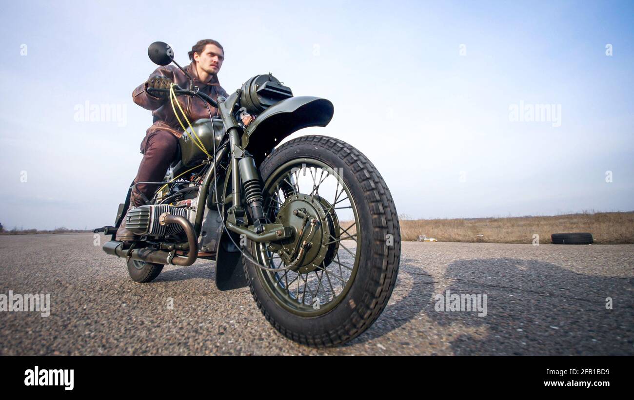 Close shoot of vintage motorcycle's wheel on the riding old empty road ...