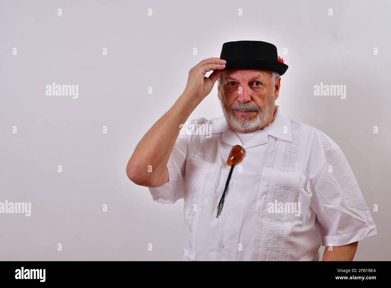 Courteous senior man looking serious is tipping his hat Stock Photo - Alamy