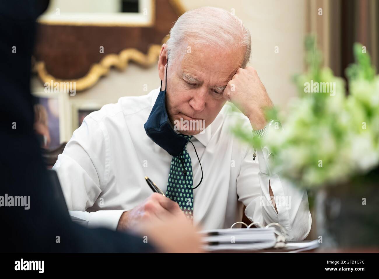 President Joe Biden takes notes during a briefing on the shootings in ...