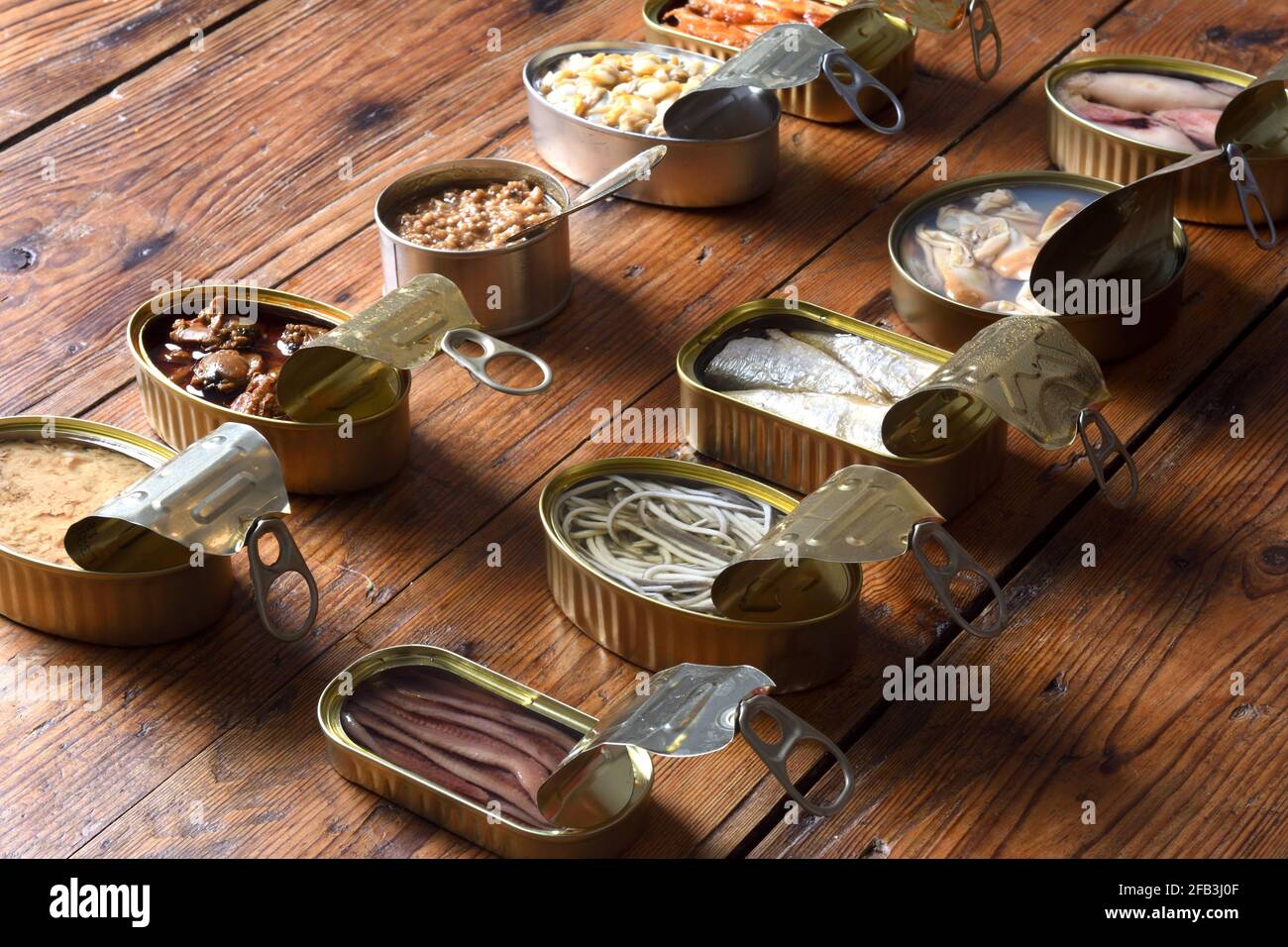 set of cans with fish and seafood on wooden background, elevated view ...
