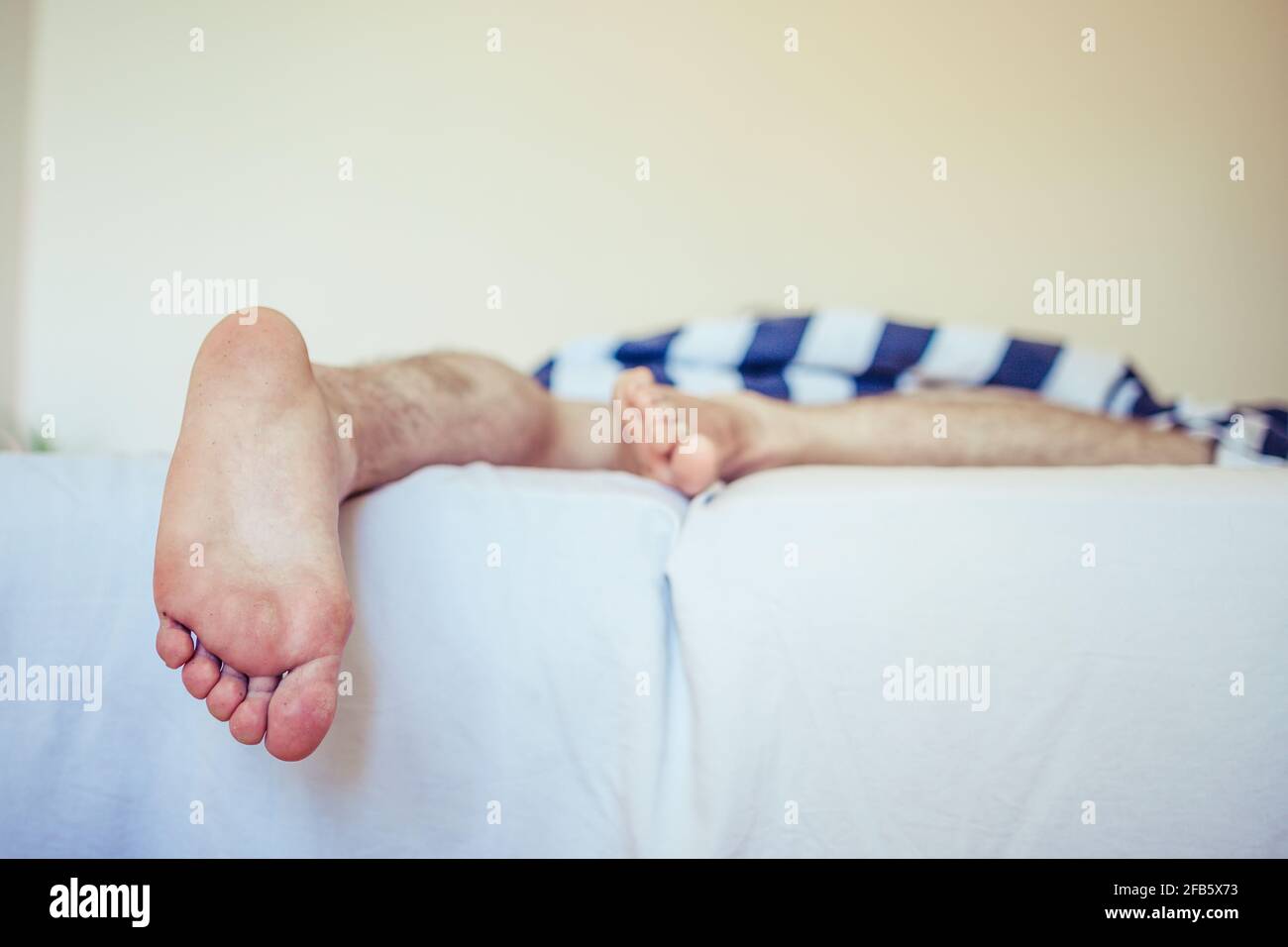 Closeup shot of a male sleeping in the bad, man feet Stock Photo - Alamy