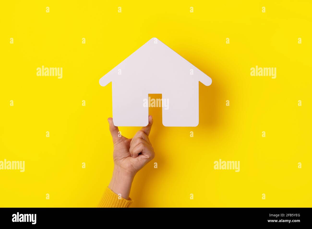 house in hand over yellow background, insurance concept Stock Photo - Alamy